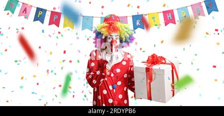 Clown with a birthday present making a finger mouth shush sign isolated ...