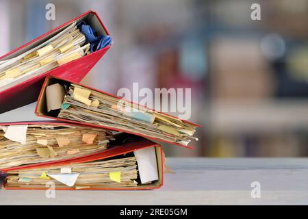 stack of dusty messy file folders with narrow depth of field, blurred ...