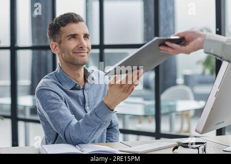 Focus on male hands passing each other folder with papers Stock Photo ...