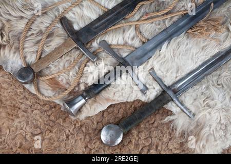 Medieval swords on sheep fur background Stock Photo - Alamy