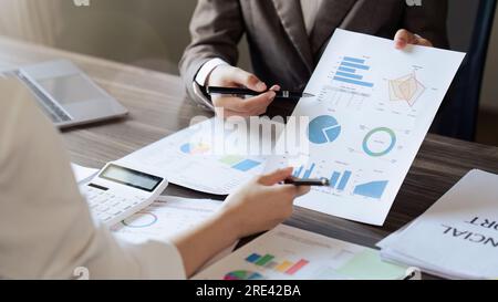 Chief and employee discuss monthly earning graph together in the office ...