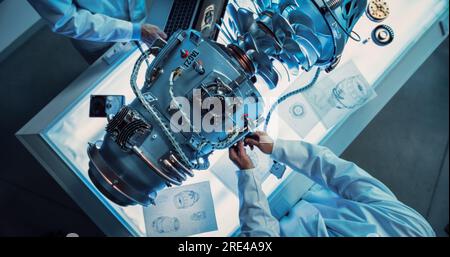 Two Professional Jet Engine Researchers Discussing Work, Using Laptop ...