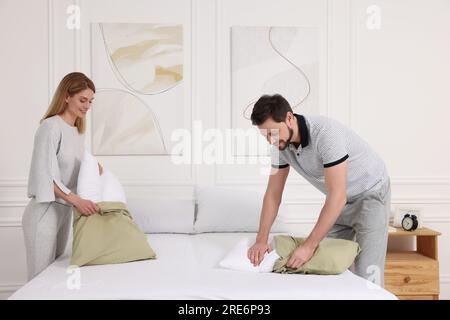 Couple changing bed linens at home. Domestic chores Stock Photo - Alamy