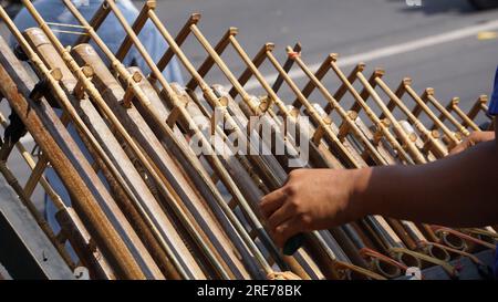 A man is playing angklung. That is a multitonal musical instrument that ...
