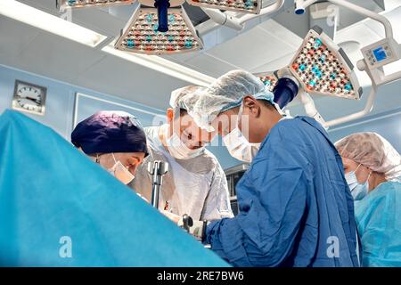 Surgeons team during complex surgical operation in a sterile operating ...