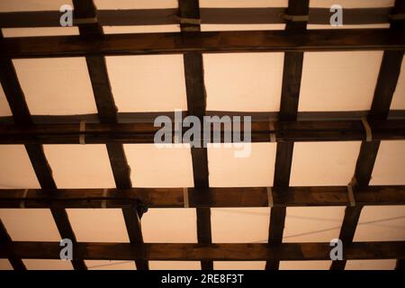 Roof inside. Roof made of planks. Interior details. Ceiling in lattice ...