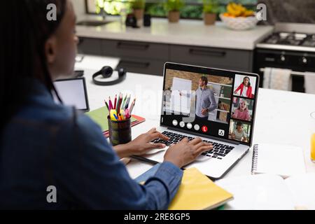 Male student having a video call with male teacher on computer at ...