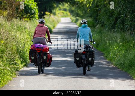 Two senior women cycle touring with full panniers Stock Photo - Alamy