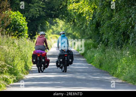 Two senior women cycle touring with full panniers Stock Photo - Alamy