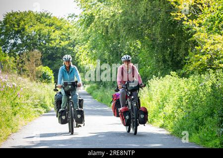 Two senior women cycle touring with full panniers Stock Photo - Alamy