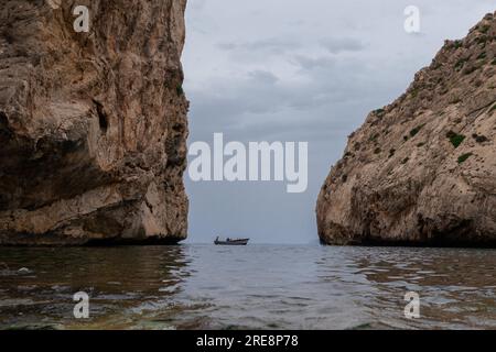 A boat on a beach between two large rocky mountains, in one of the ...