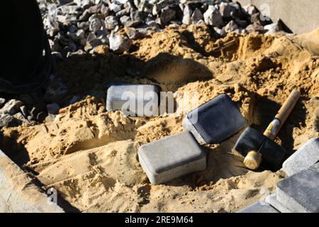 Defocus paving hammer. Stack of paving stones. Garden brick pathway ...