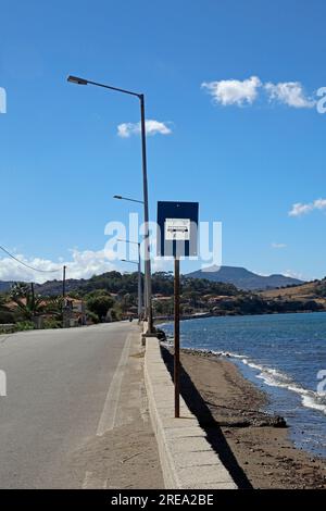 Greek sign for a bus stop alongside coast road from Petra village Stock ...