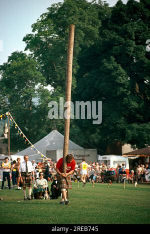 A strong kilted athlete prepares to toss the caber at the Highland ...
