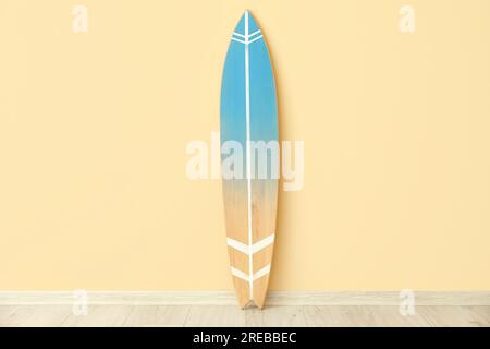 Wooden surfboard near beige wall Stock Photo - Alamy