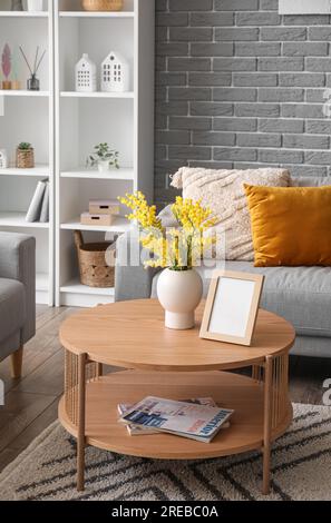 Shelving unit with vase, frame and pillows near light curtain in room ...