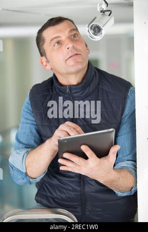 Electrician inspecting surveillance camera Stock Photo - Alamy