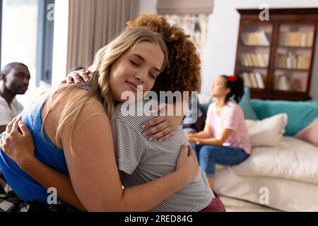 Supportive diverse female friends hugging each other at group therapy ...