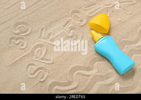 Creative composition with sunscreen cream and drawings on sand Stock ...