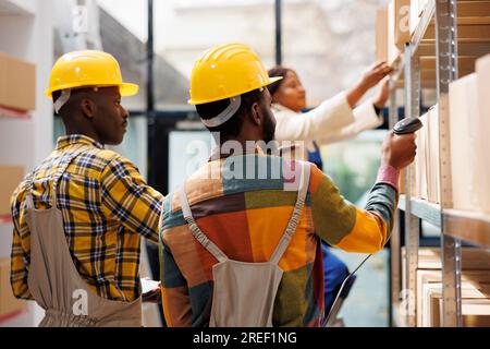 African american logistics managers scanning freight in storage ...