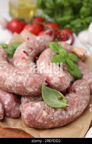 Raw sausages or bratwurst on parchment paper and ingredients for ...