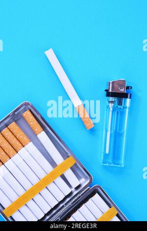 Cigarettes, case and lighter against pale blue Stock Photo - Alamy