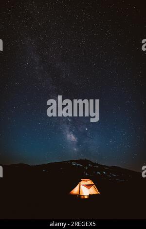 astrophotography of glowing tent at a campsite under milky way galaxy ...