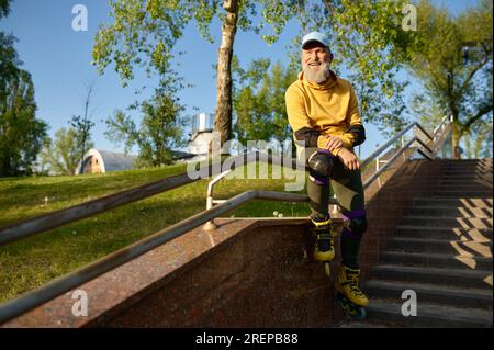 Senior man wearing roller skates rest sitting on stair railing Stock ...