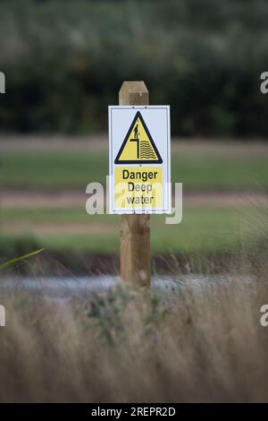 Danger deep water sign next to pond Stock Photo - Alamy