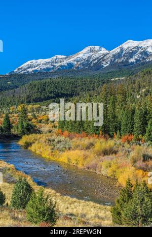 ruby river below snow-capped peaks of the snowcrest range in autumn ...