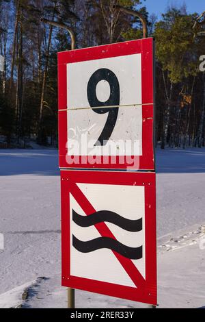 Speed limit and prohibition of causing waves sign next to a frozen ...