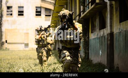 Squad of soldiers running forward and attacking enemy during military ...