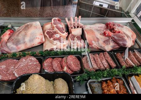The butcher shop's refrigerated display showcases a variety of raw ...