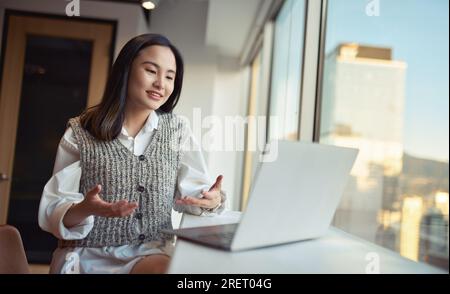 young asian woman having video call consultation waving greeting using ...