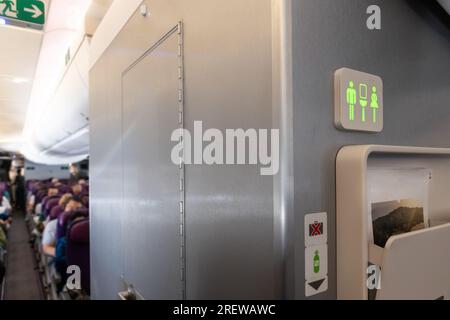 Lavatory signage on airplan cabin wall lighted green suggests it is not ...