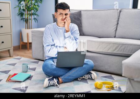 Non binary person studying using computer laptop sitting on the floor ...