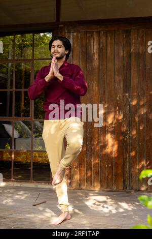 Focused indian man practicing yoga on sunny terrace Stock Photo - Alamy