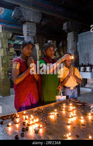 Devout lighting an oil lamp. Temple of the Sacred Tooth Relic. Kandy ...