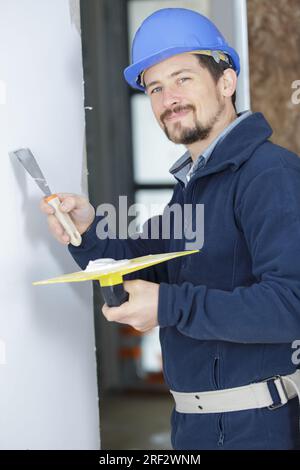 Man plasterer with tools wear protective hard hat, guest worker concept ...