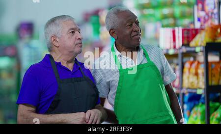 Senior diverse employees of grocery store discussing management of ...