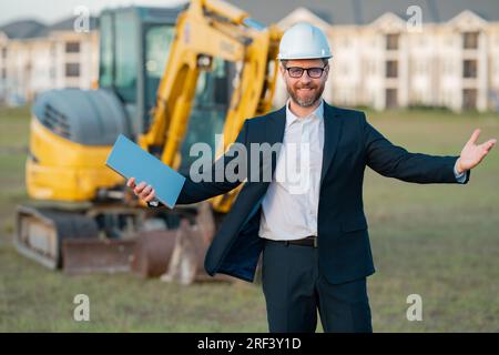 Construction owner near excavator. Confident construction owner in ...