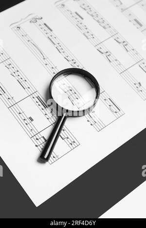 Magnifier with music sheet on black and white background Stock Photo ...