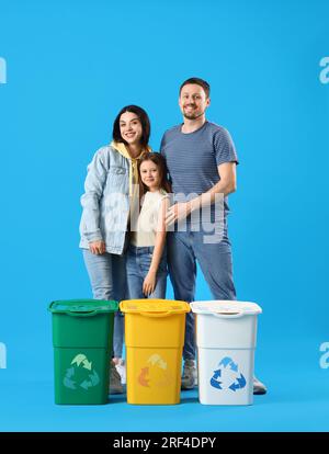 Family with recycle bins on blue background Stock Photo - Alamy