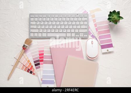 Color palettes, PC keyboard, notebooks and scissors on light background ...