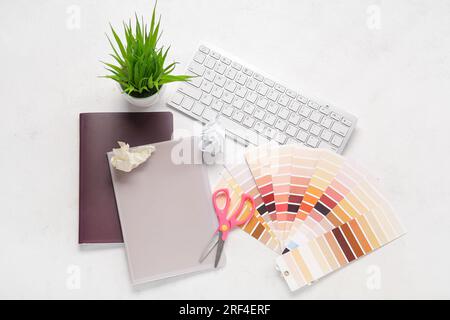 Color palettes, PC keyboard, notebooks and brush on light background ...