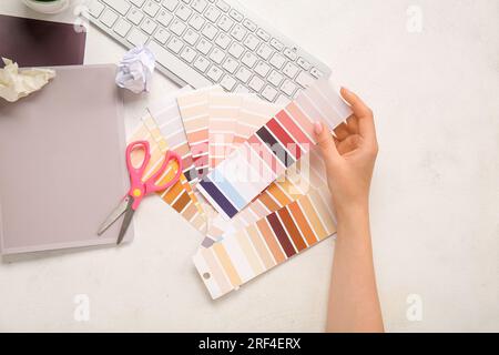 Color palettes, PC keyboard, notebooks and scissors on light background ...