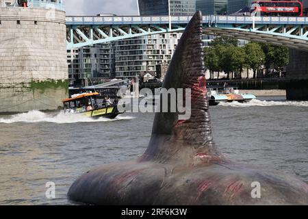Floating models of megalodon shark fins by Tower Bridge during a ...