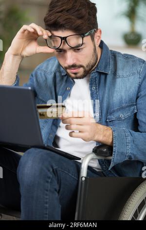 disabled person reads credit card and uses pc Stock Photo - Alamy