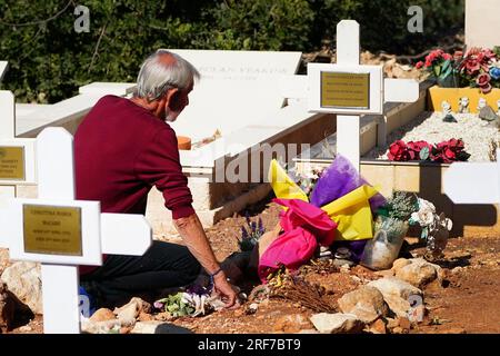 David Hunter lays flowers at the grave of his wife Janice Hunter at a ...