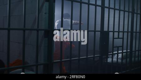 Male African American prisoner in orange uniform does shadow boxing in ...